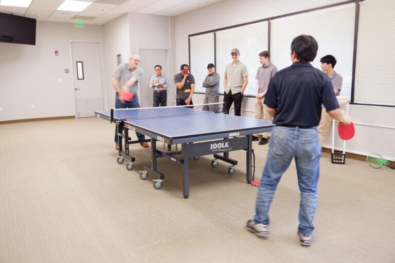 Enjoying a fun game of ping pong with IT folks - Building Strong