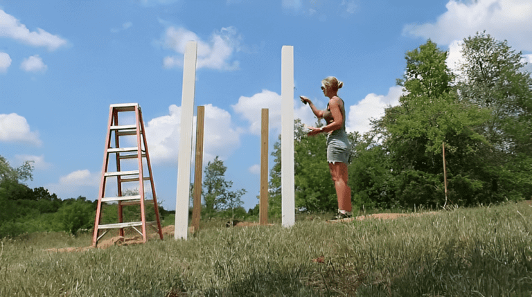 Dena painting the posts - Building Strong